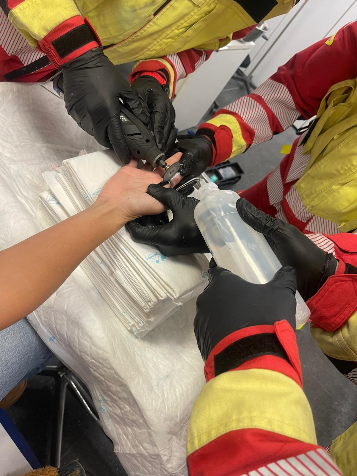 Firefighters remove a ring from a patient at Molina Orosa Hospital